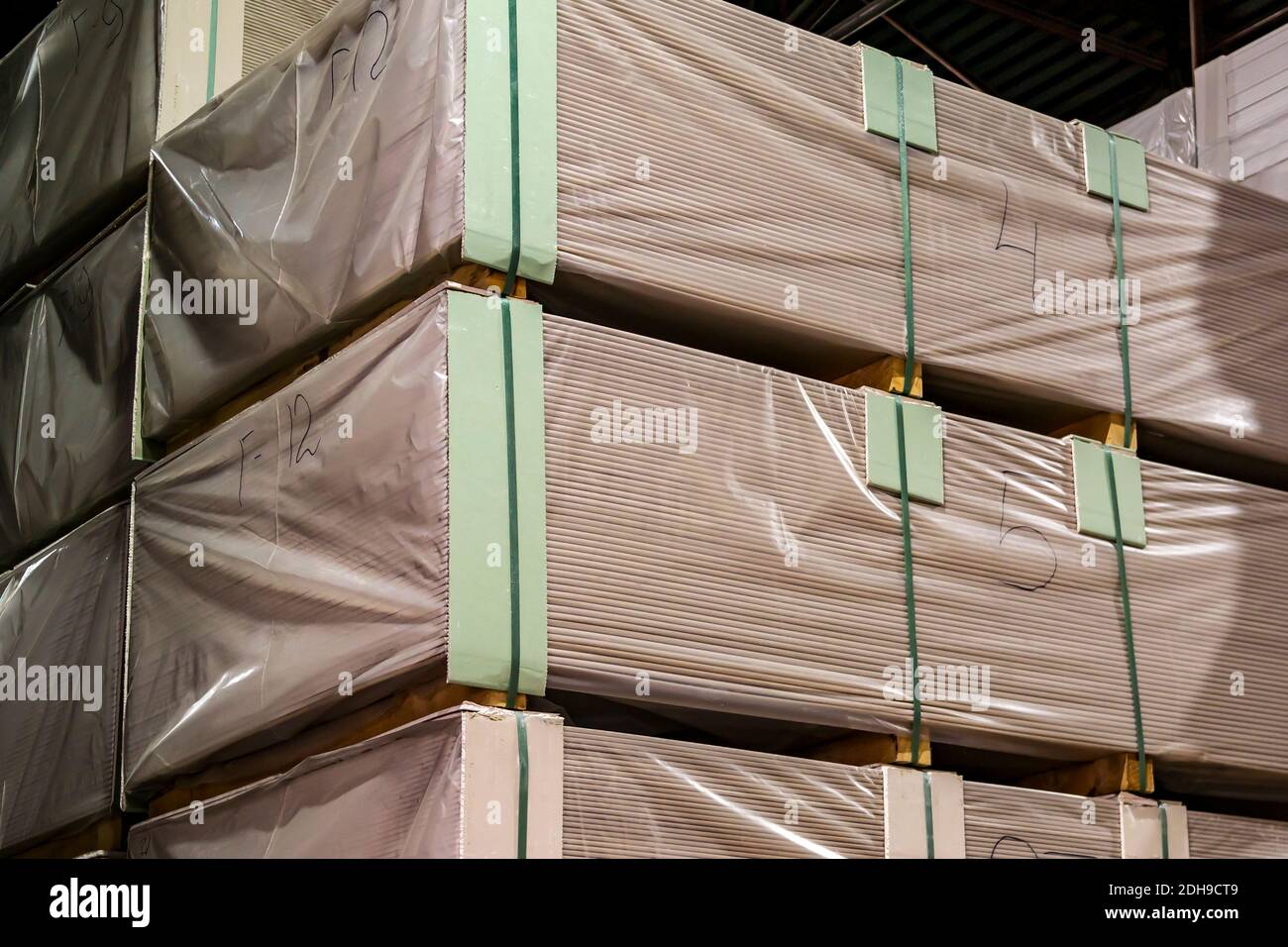 numbered and packed in plastic film pallets with drywall are stacked on ...