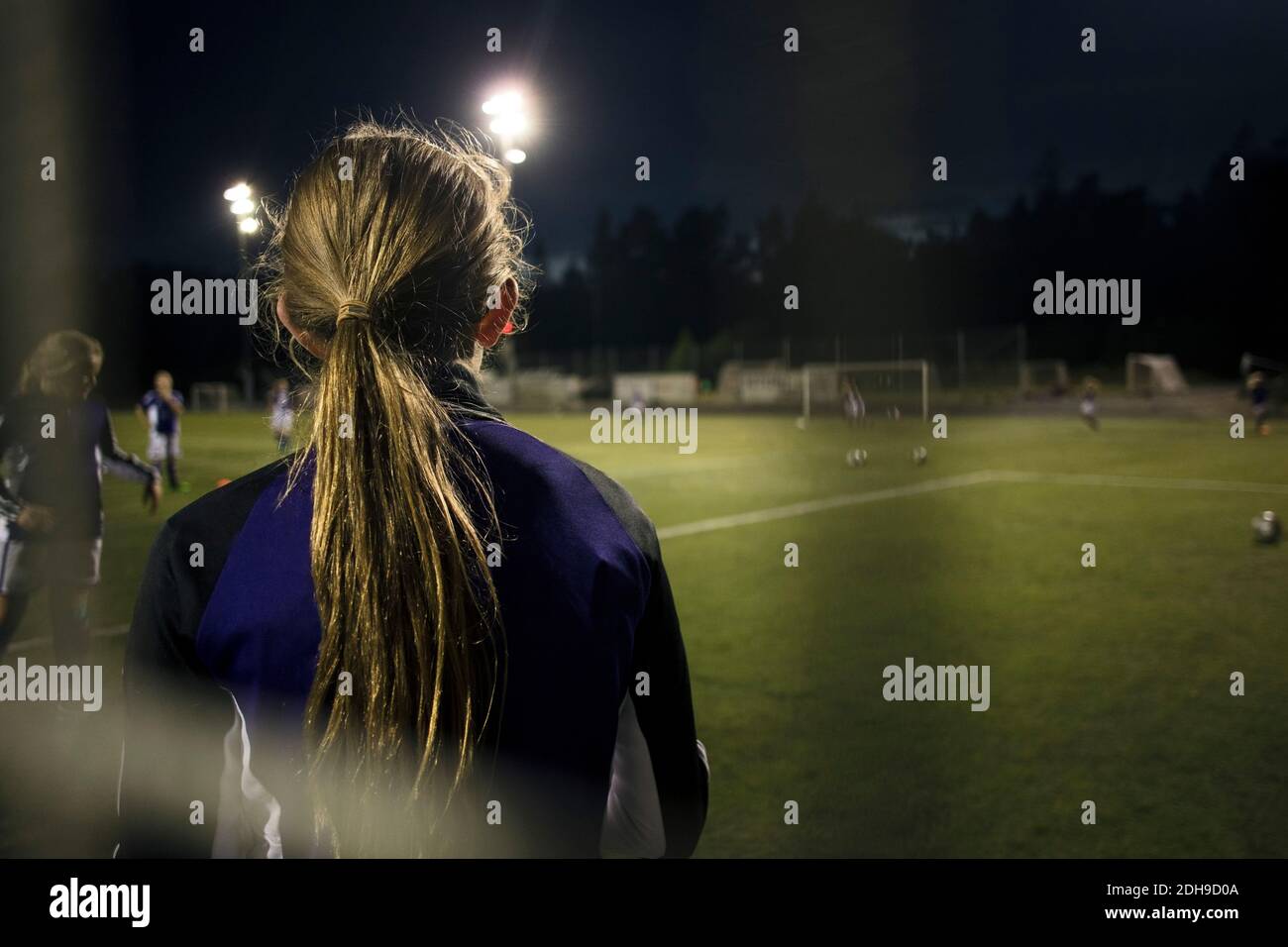 Side view of girl seen through goal post net on soccer field Stock ...