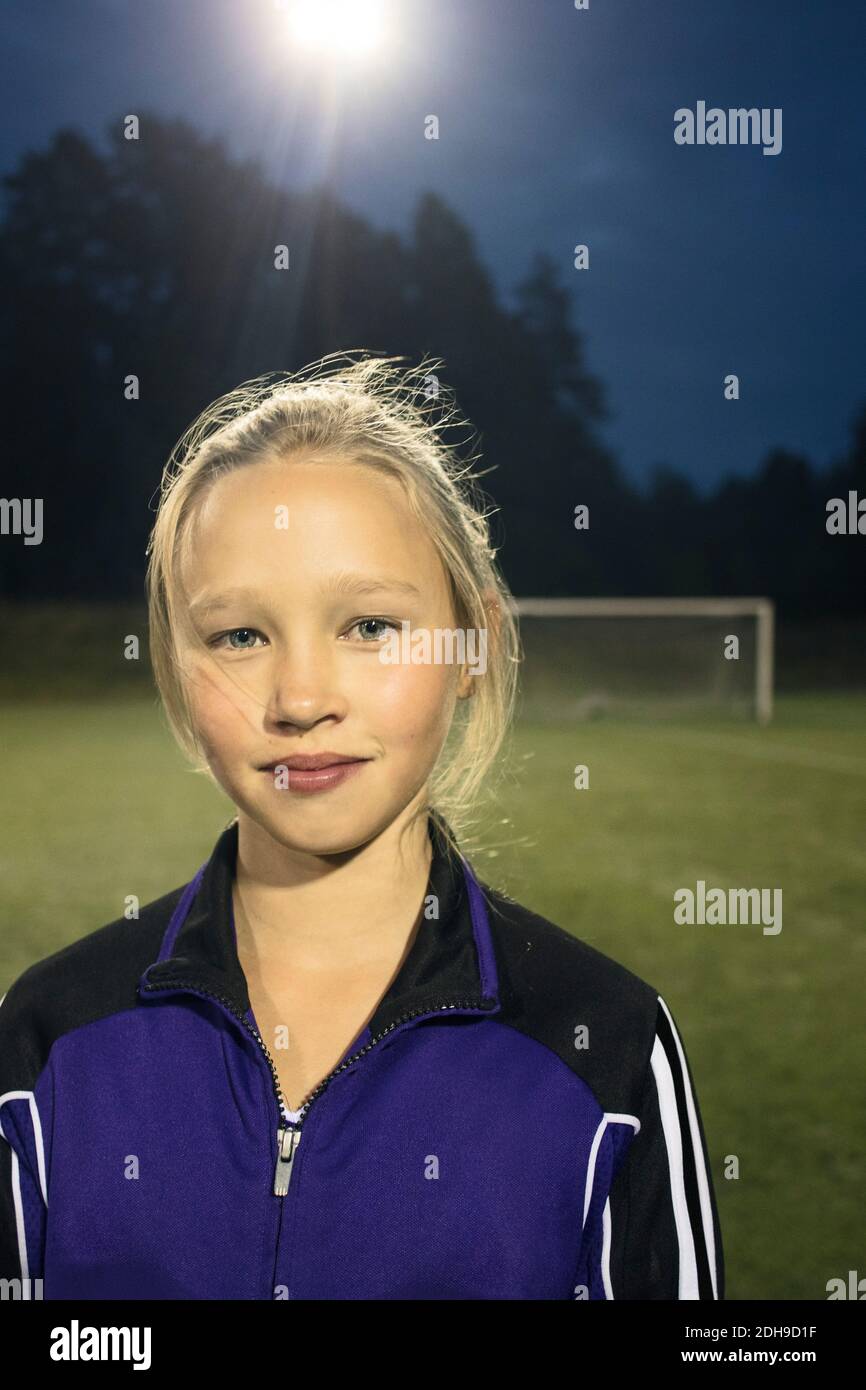 Portrait of confident girl standing on soccer field at night Stock ...