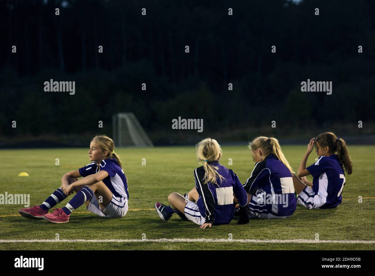 Athletes relaxing on soccer field against trees Stock Photo - Alamy