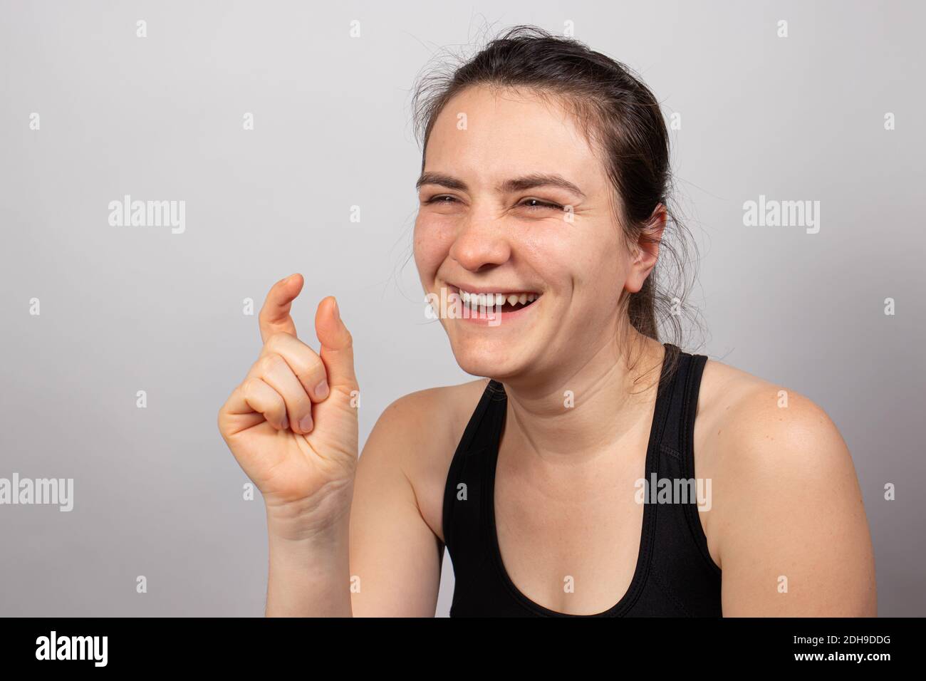 The woman laughs and shows the finger the symbol is small. Small salary ...