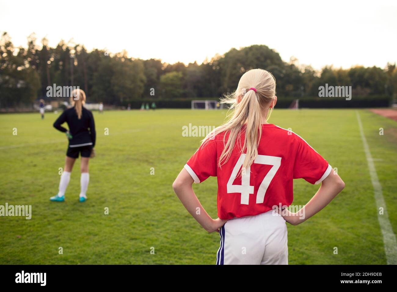 Rear view of girl standing on soccer field Stock Photo - Alamy