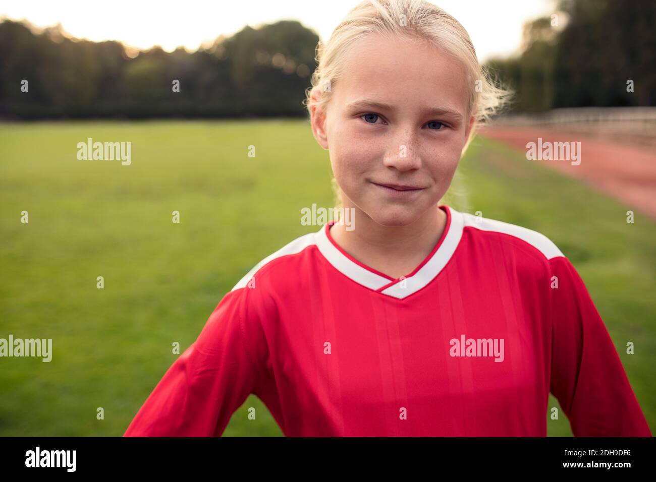 Portrait of girl standing on soccer field Stock Photo - Alamy