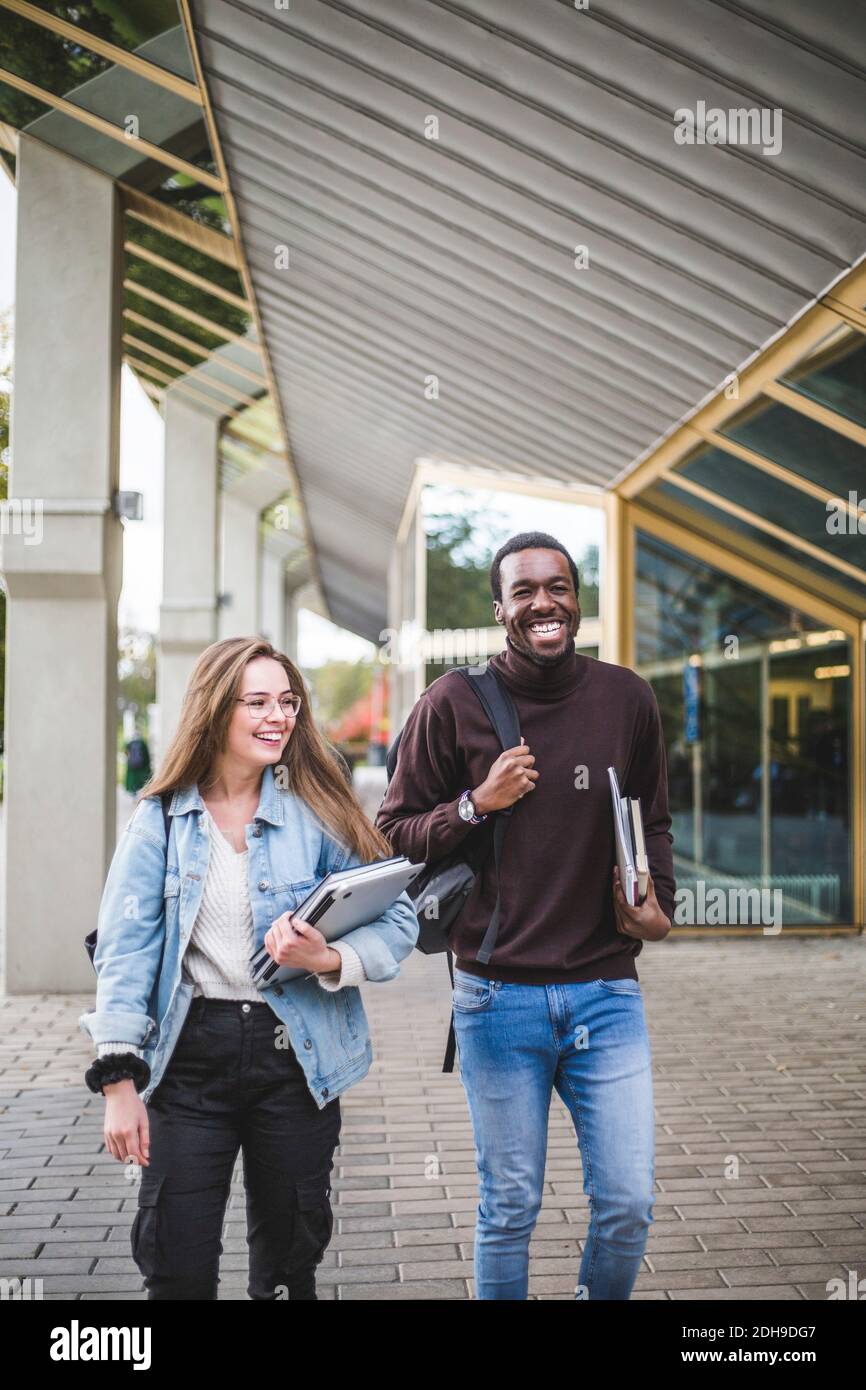 Happy male and female students at university Stock Photo - Alamy