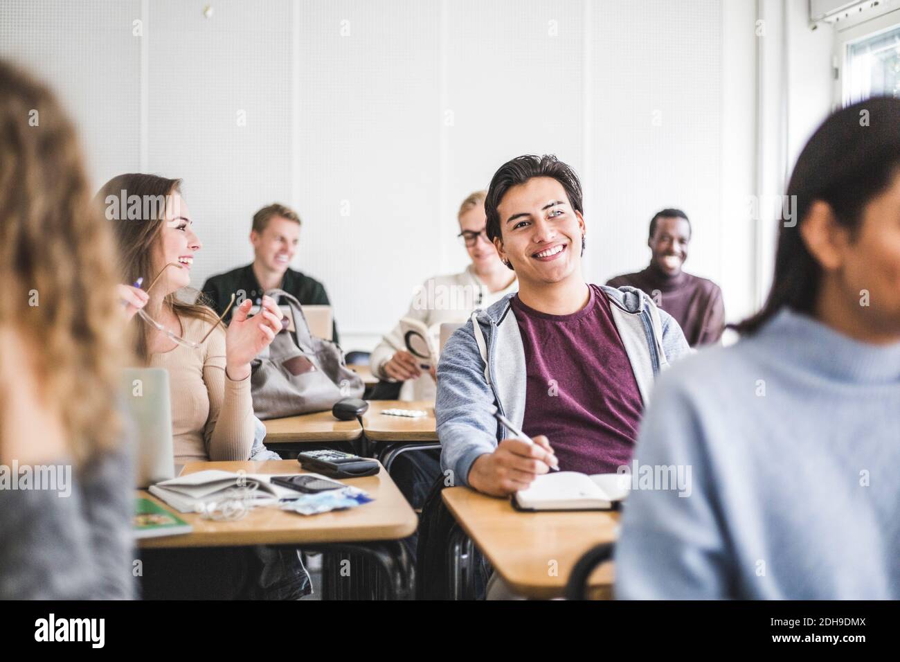Smiling male and female students in classroom at university Stock Photo ...