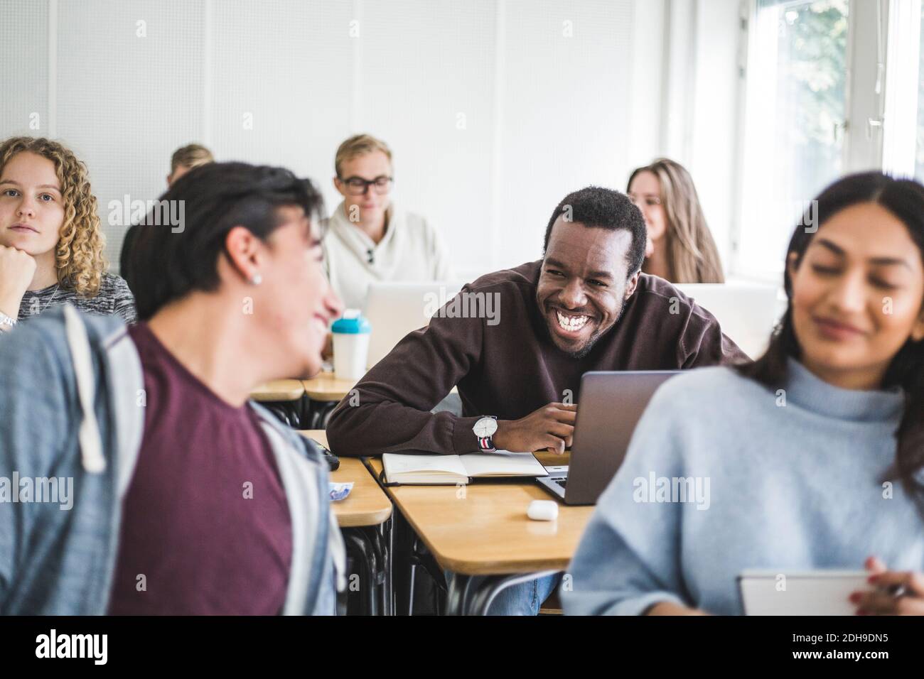 Cheerful male friends talking in classroom Stock Photo - Alamy