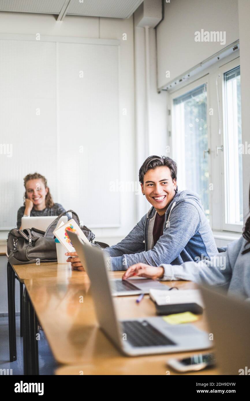 Smiling young man studying in university classroom Stock Photo - Alamy