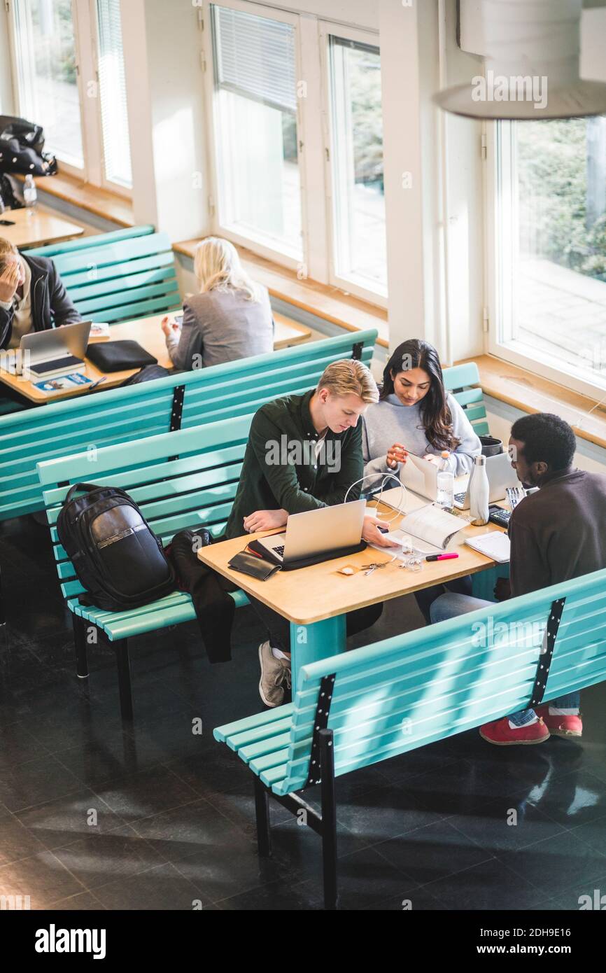 Male and female students studying at table in cafeteria Stock Photo - Alamy