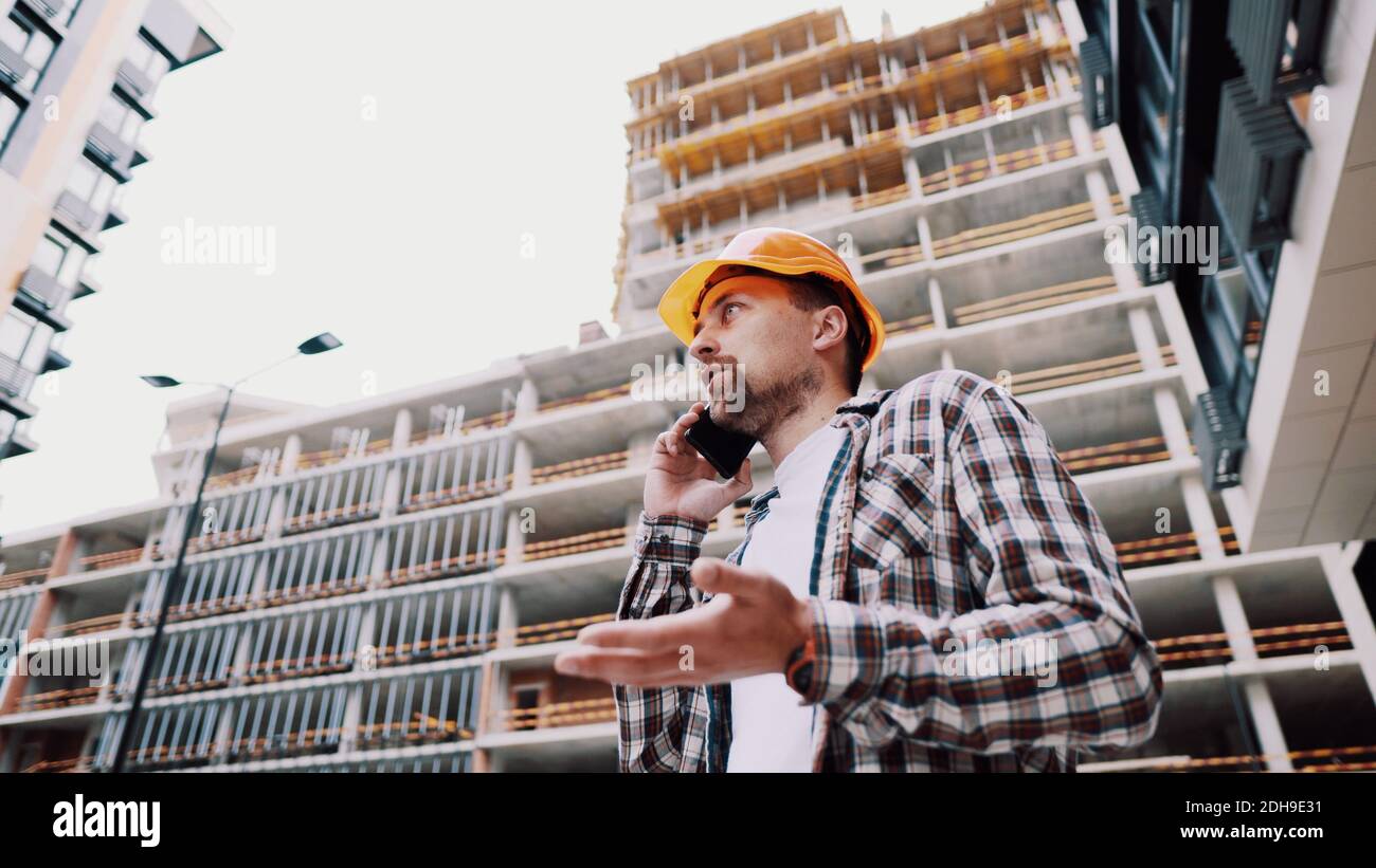 Engineer talking on phone. Architect using phone on construction site ...