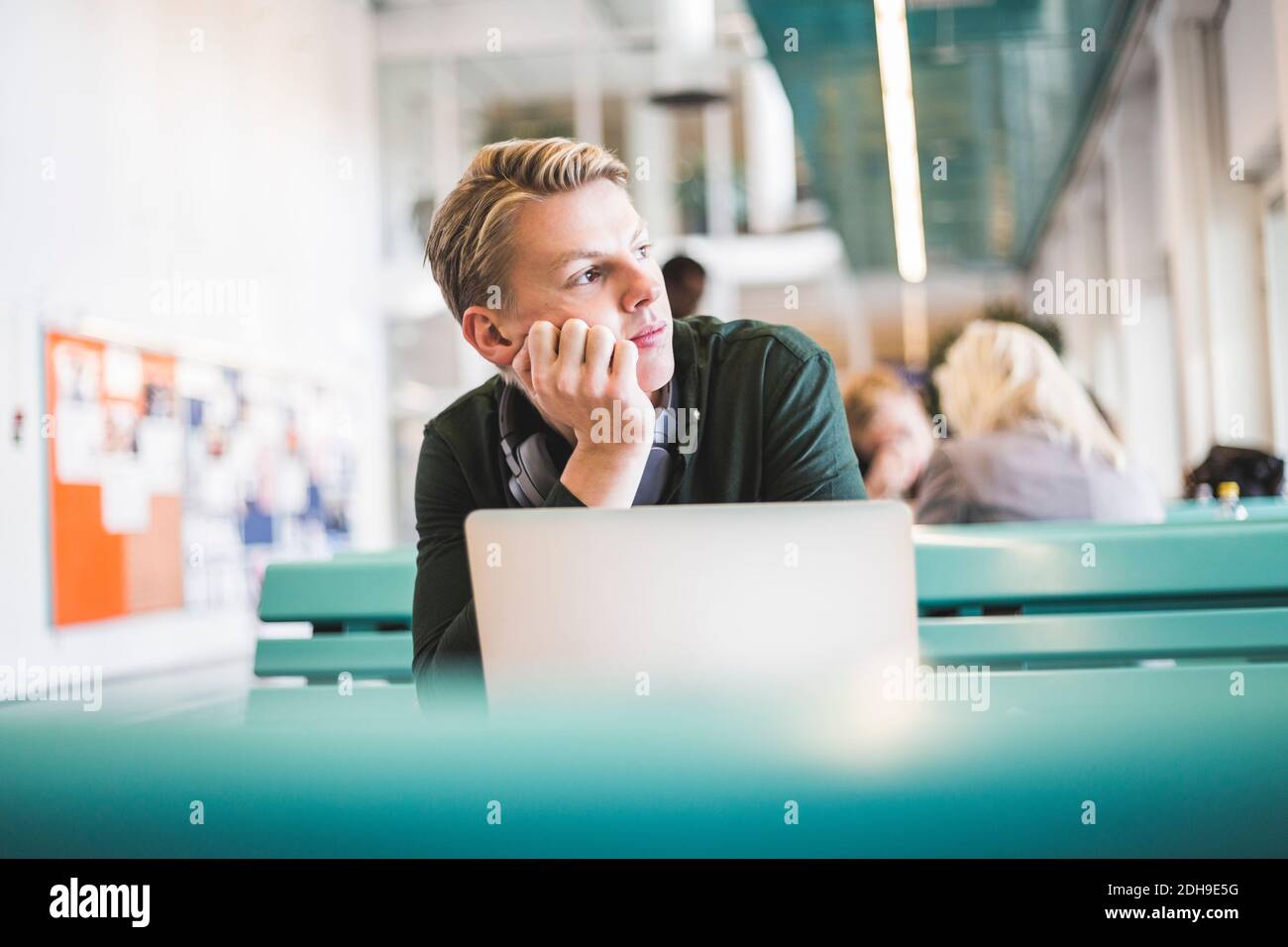 Thoughtful young male student sitting in cafeteria at university Stock ...