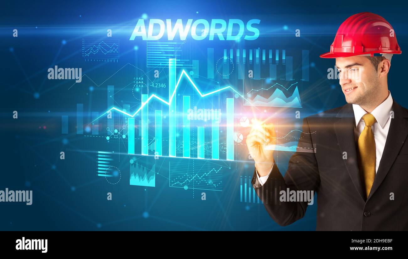 Handsome businessman with helmet drawing ADWORDS inscription ...