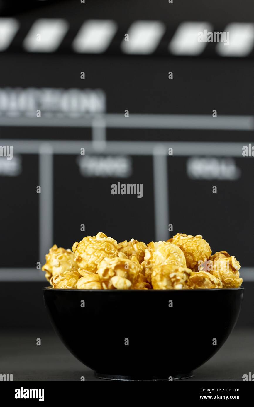 A Vertical shot of a delicious sweet popcorn in a bowl next to a ...