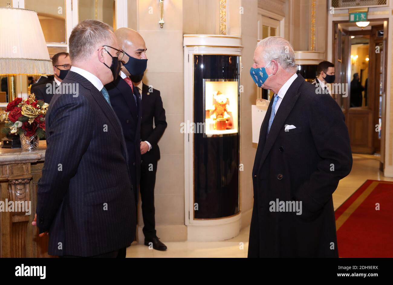 The Prince of Wales wears a face mask as he speaks to staff during a ...