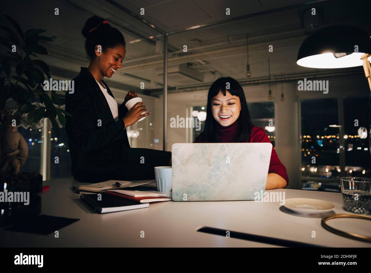 Happy female professionals working late during meeting in office Stock ...