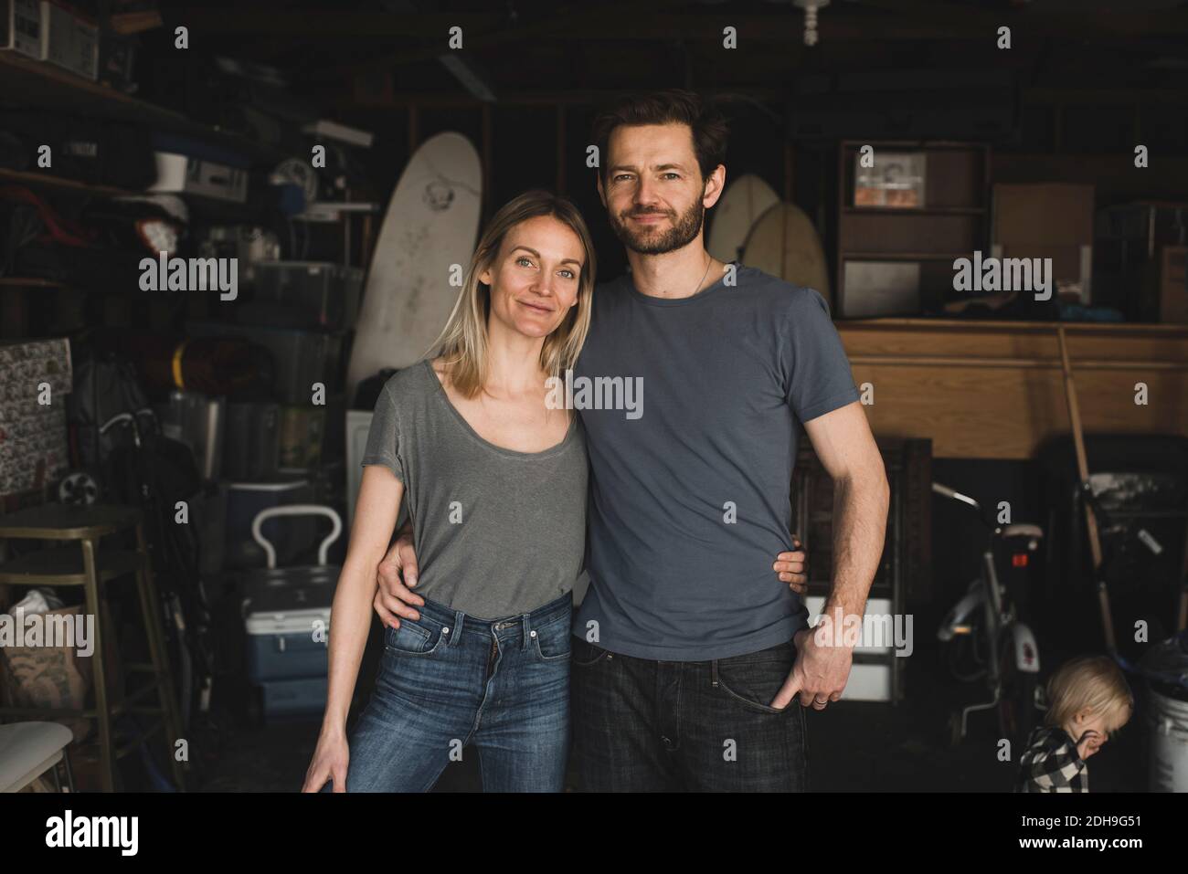 Portrait of loving parents standing by daughter at storage room Stock ...