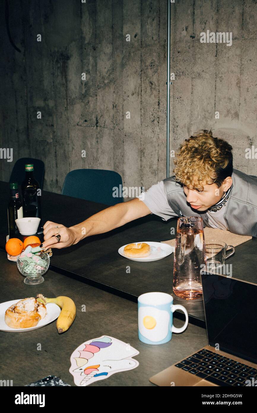 Man eating candy at table in office Stock Photo - Alamy
