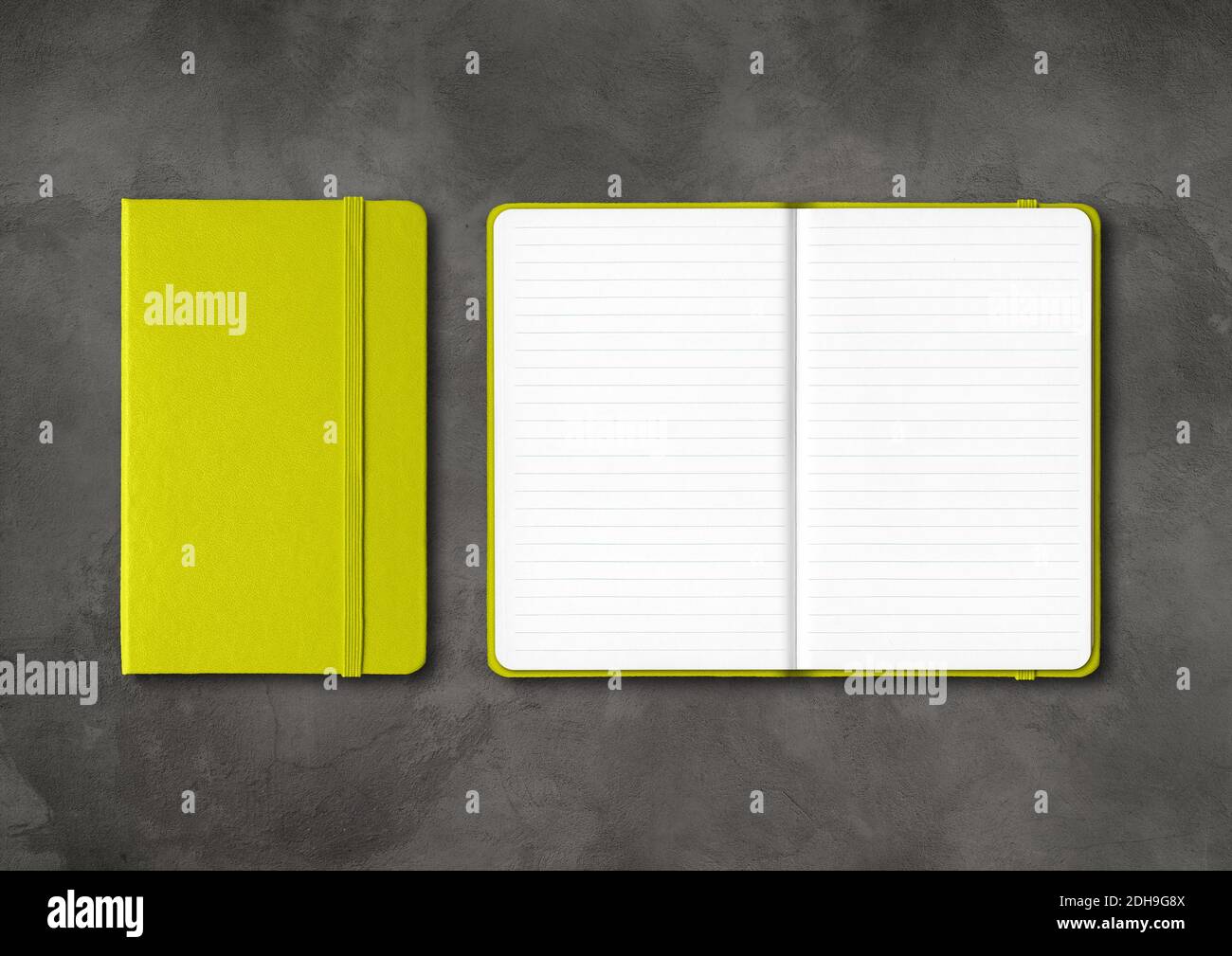 Lime green closed and open lined notebooks on dark concrete background ...