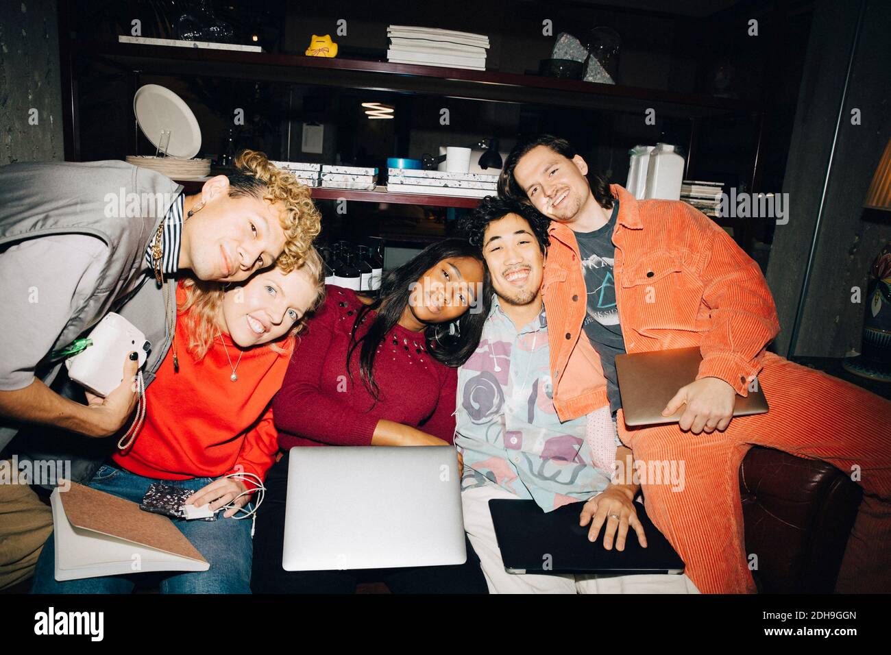 Portrait of smiling entrepreneurs sitting in creative office Stock ...