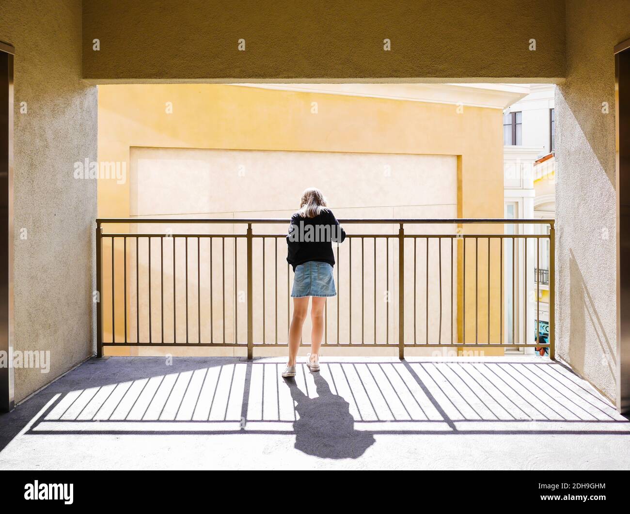 Full length rear view of girl standing by railing Stock Photo - Alamy