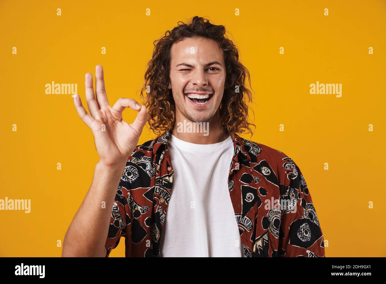 Photo of joyful handsome guy winking and showing ok sign isolated over ...
