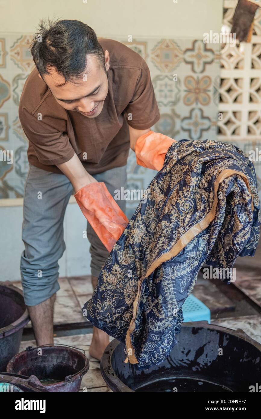 a portrait of man giving the water color to the batik cloth Stock Photo ...