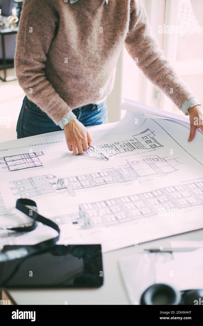 Architect looking at blueprint in home office Stock Photo - Alamy
