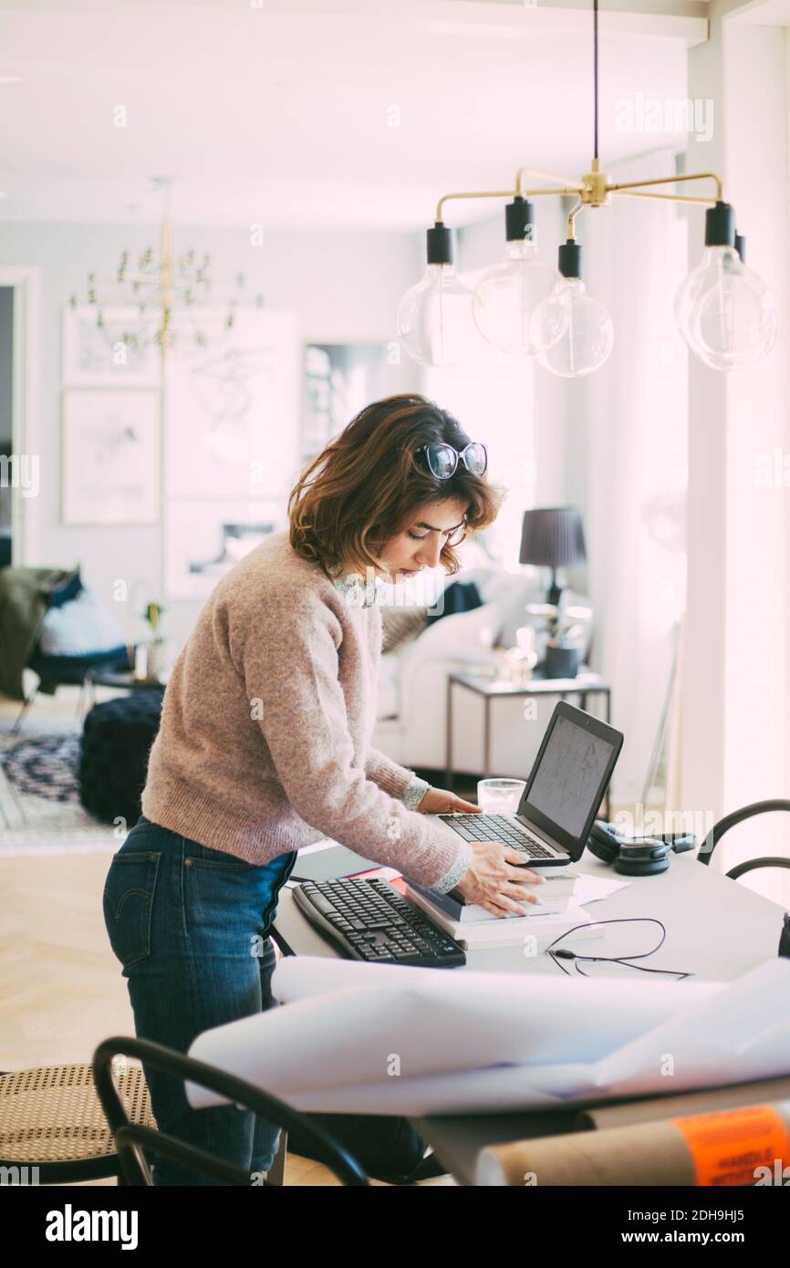 Woman setting up workplace at home Stock Photo - Alamy