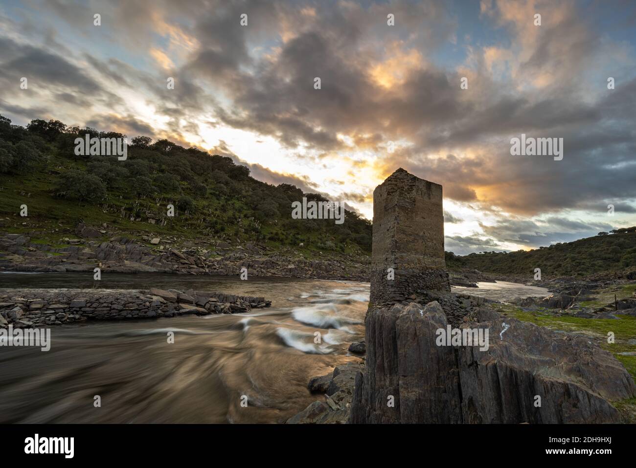 A beautiful sunset landscape over an ancient tower on the bank of the ...