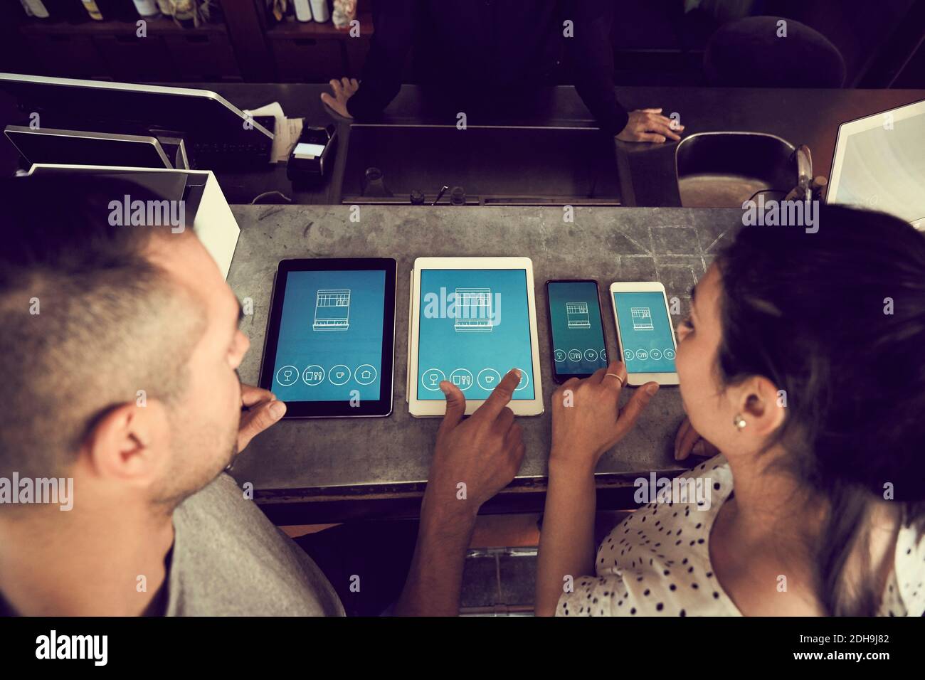 High angle view of male and female customers ordering through digital ...