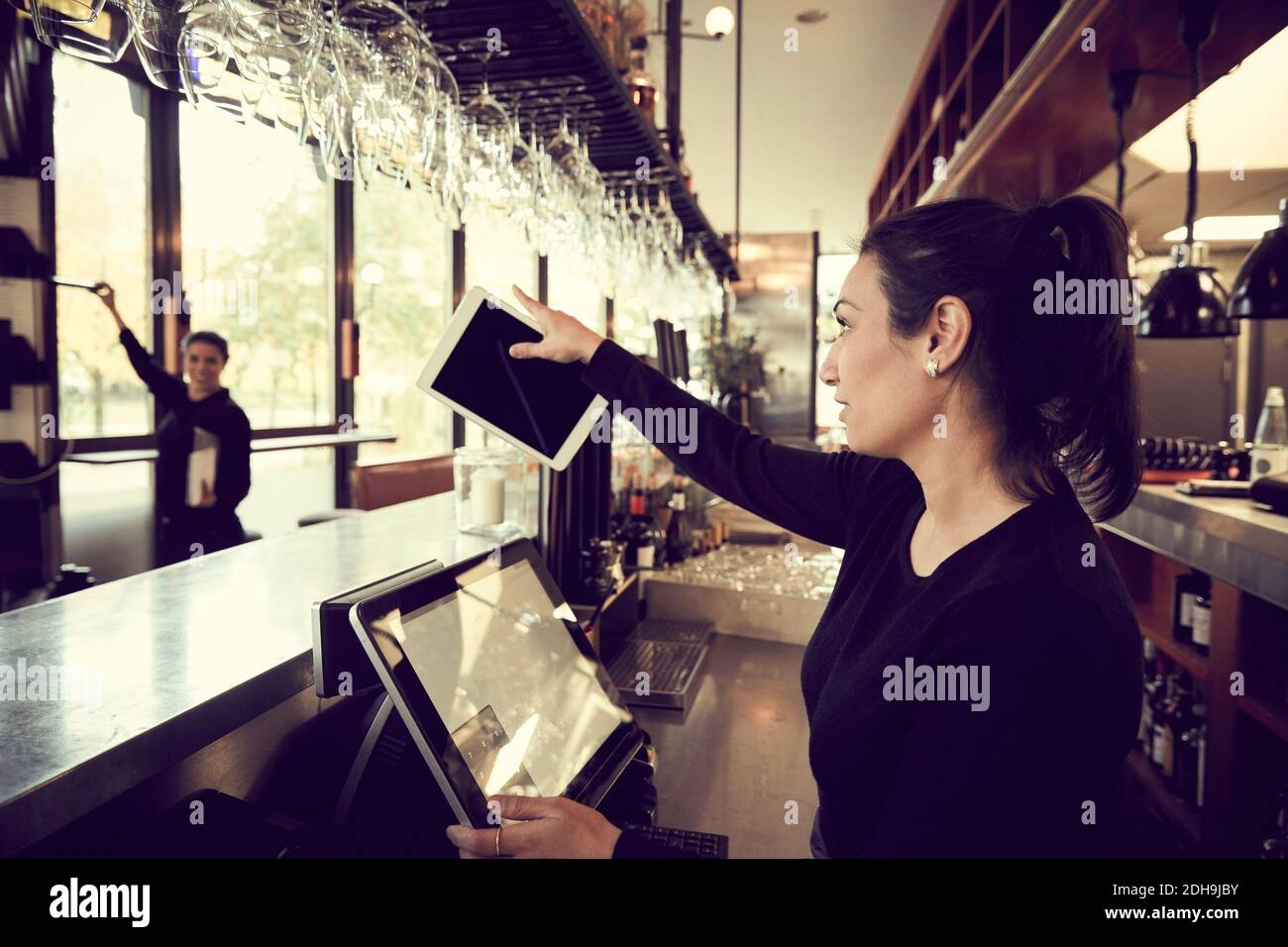 Side view of coworker pointing while talking to owner in cafe Stock ...