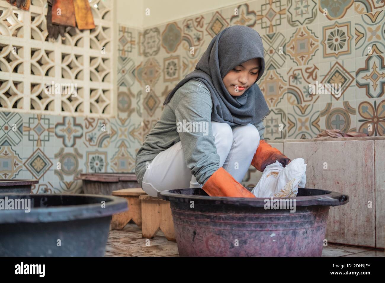 a woman washes the finished batik cloth with soapy water Stock Photo ...
