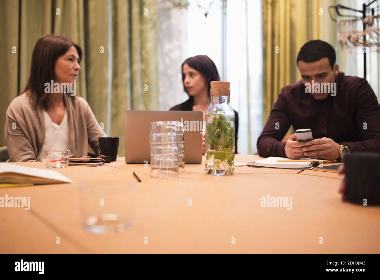 Business people sitting at conference table in board room Stock Photo ...