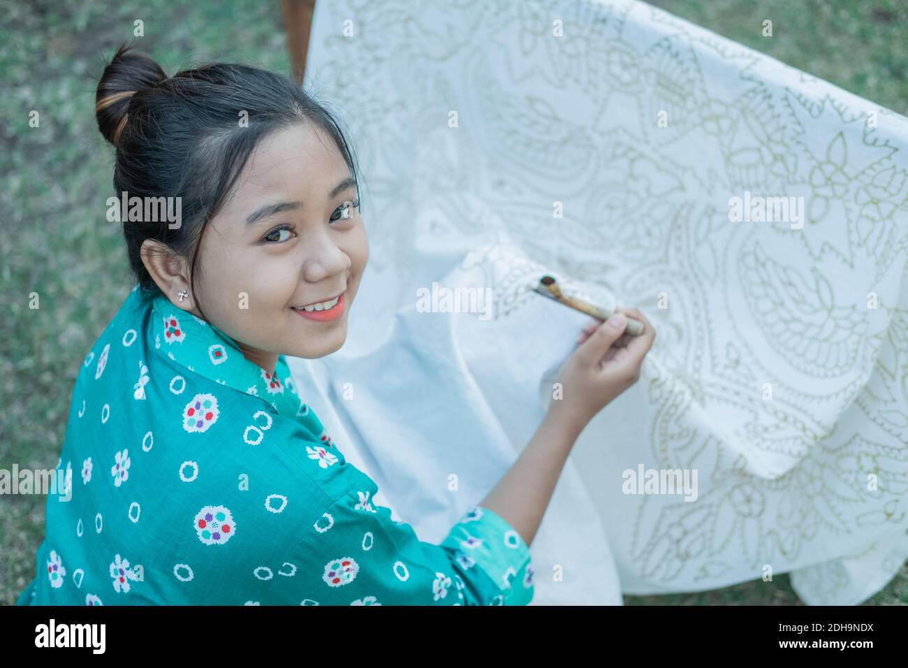 portrait young woman drawing batik on a white cloth using canting Stock ...
