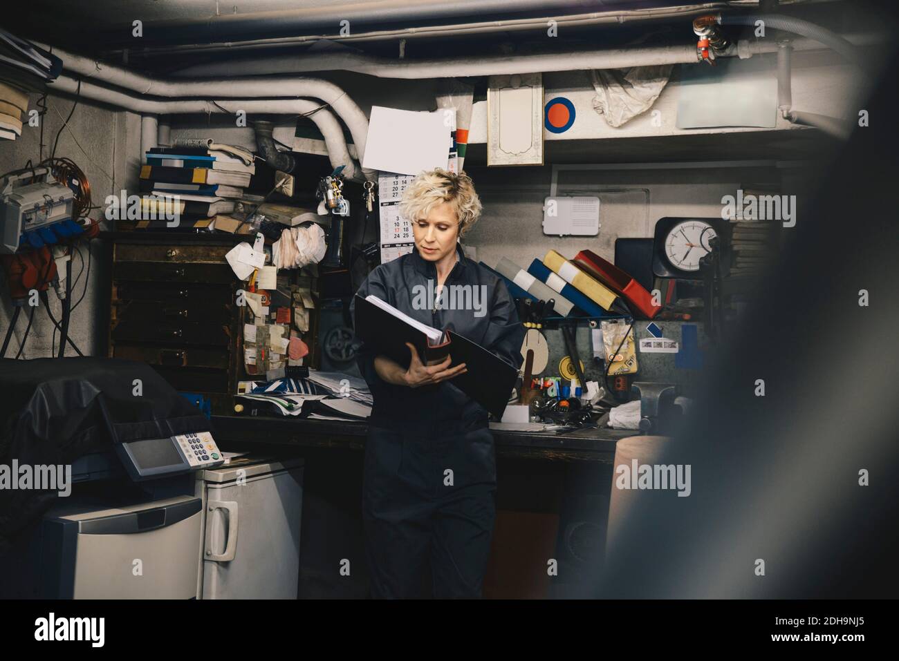 Female mechanic reading document in auto repair shop Stock Photo - Alamy