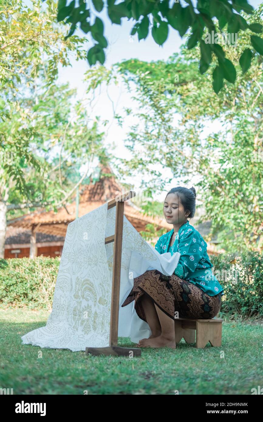 portrait young woman drawing handmade traditional batik pattern in the ...