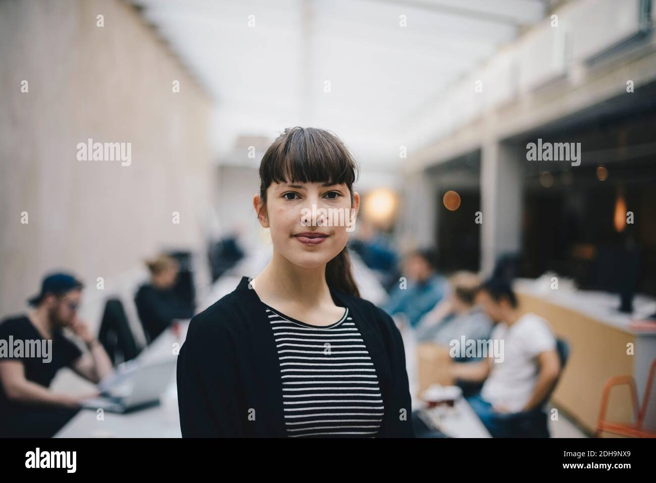 Portrait of female confident computer programmer at office with ...