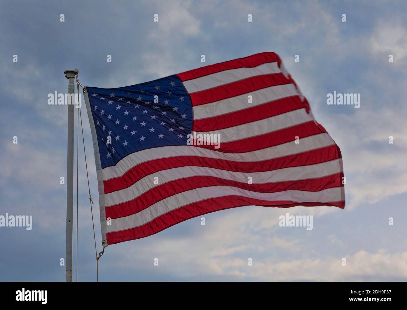 Motion blur on a flying American flag with clouds behind Stock Photo ...