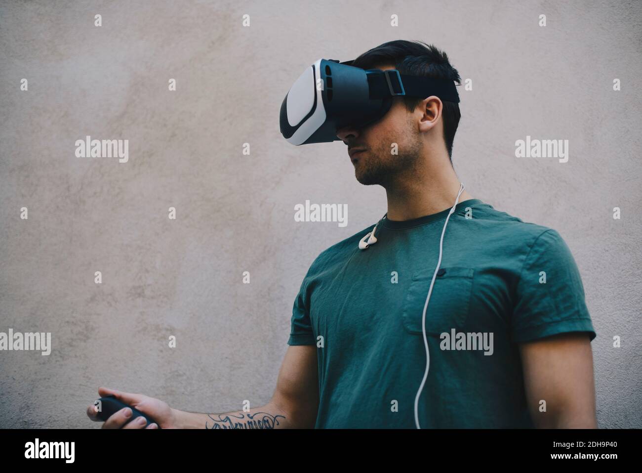 Computer Programmer Using Vr Glasses And Remote Control Against Beige