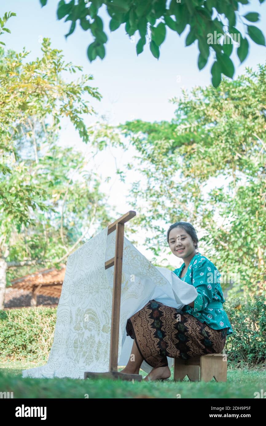 portrait young woman drawing batik on a white cloth using canting Stock ...