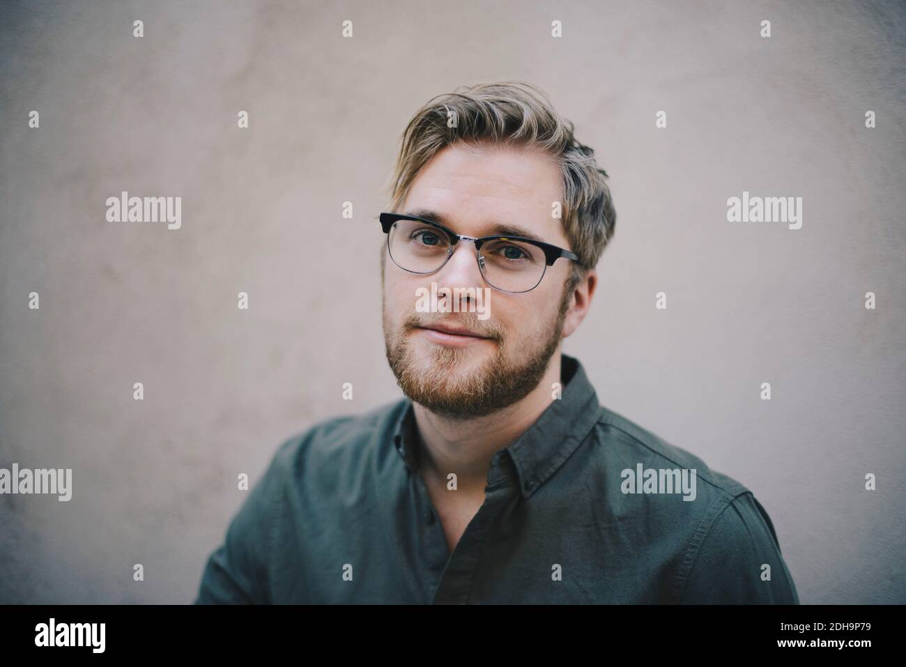 Portrait of male computer programmer against beige wall in office Stock ...