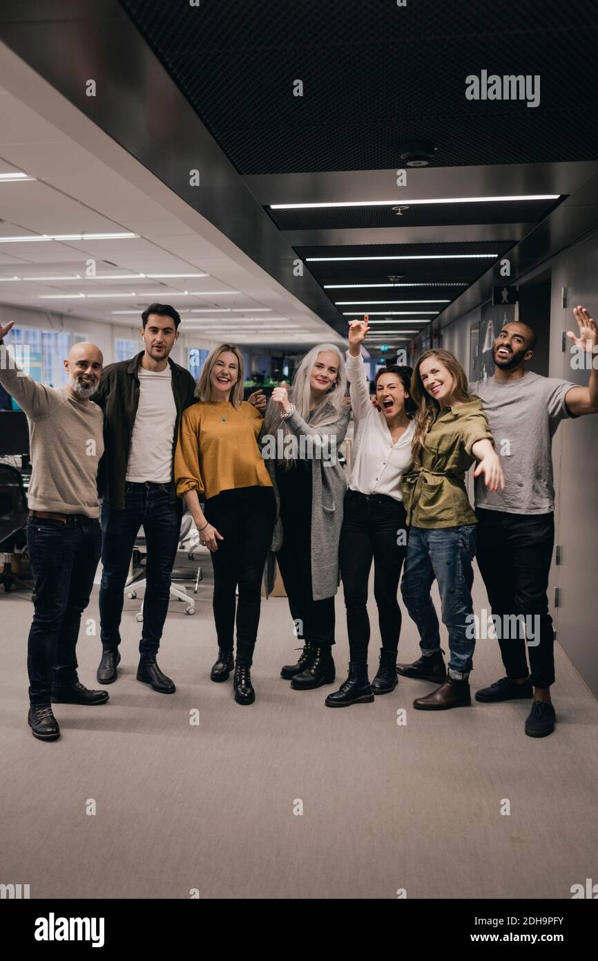 Portrait of business team cheering while standing together at open ...