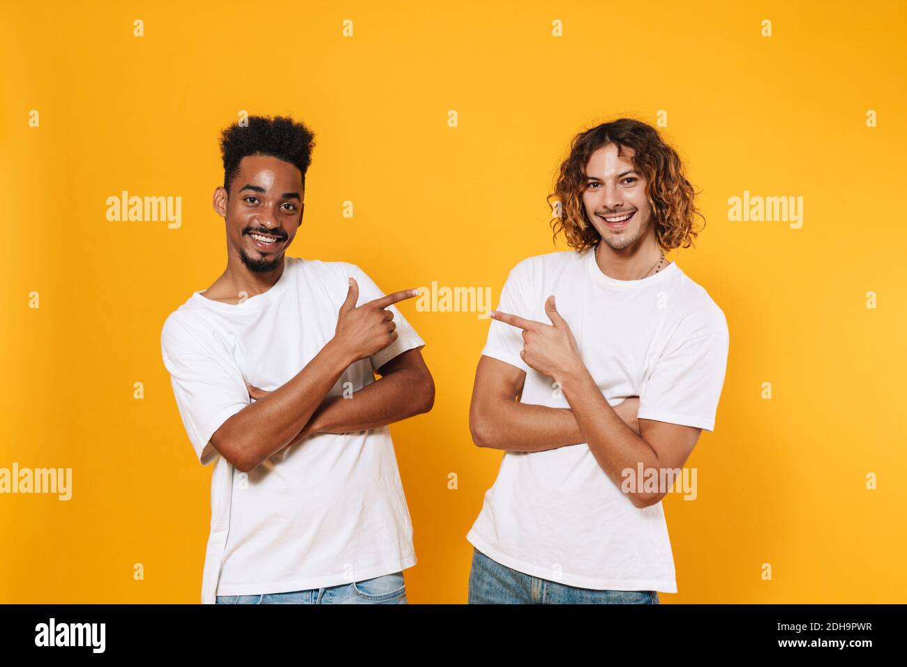 Happy multicultural two guys smiling and pointing fingers at each other ...