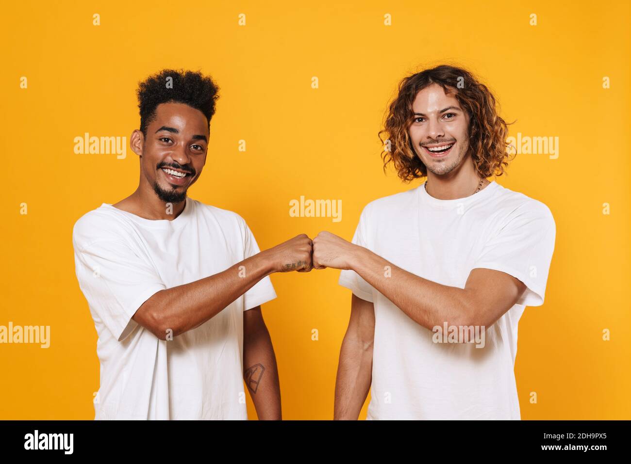Happy multicultural two guys smiling and fist bumping isolated over ...