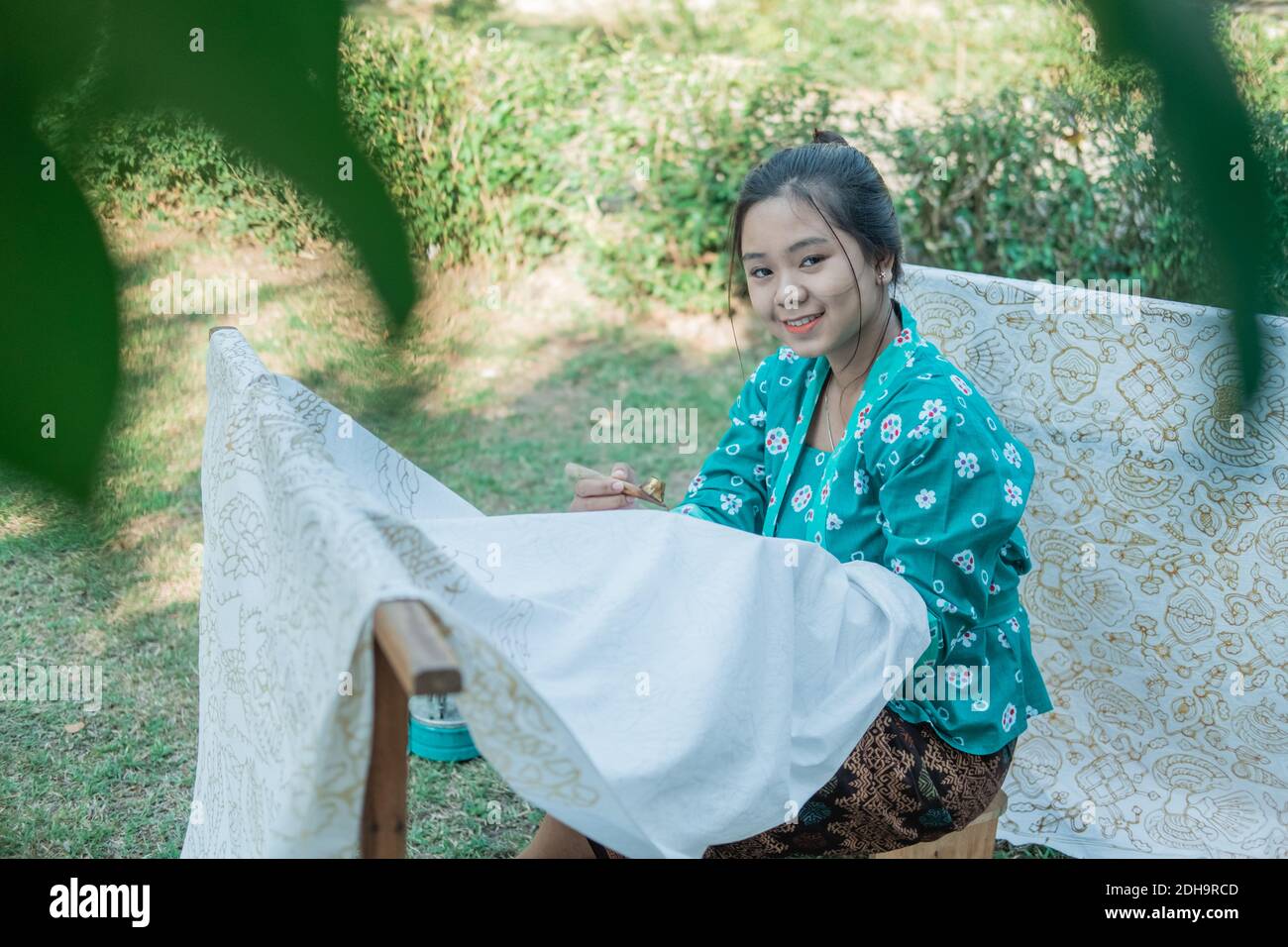 portrait young woman drawing batik on a white cloth using canting Stock ...