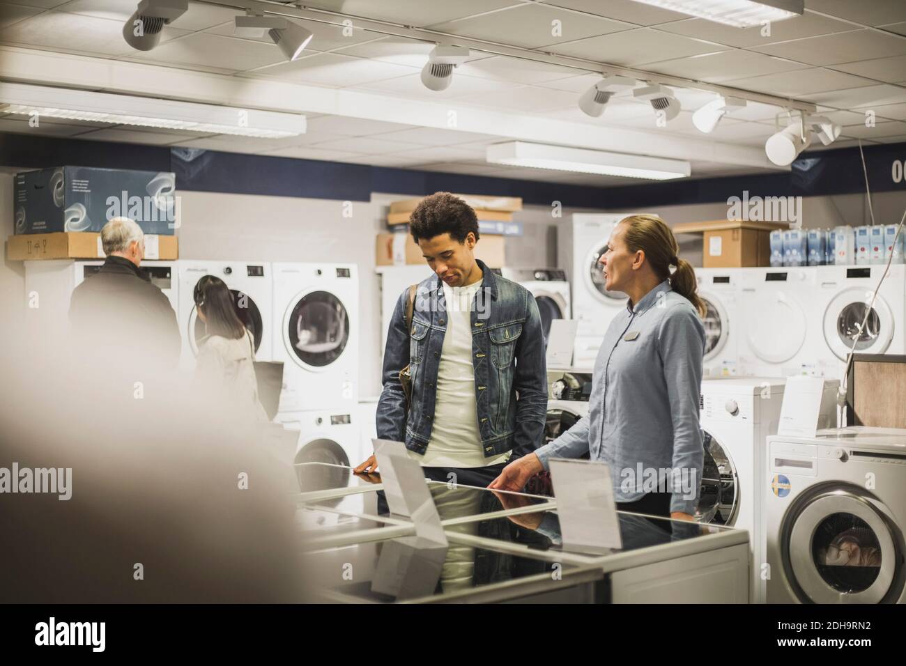 Mature owner talking to male customer in electronics store Stock Photo ...