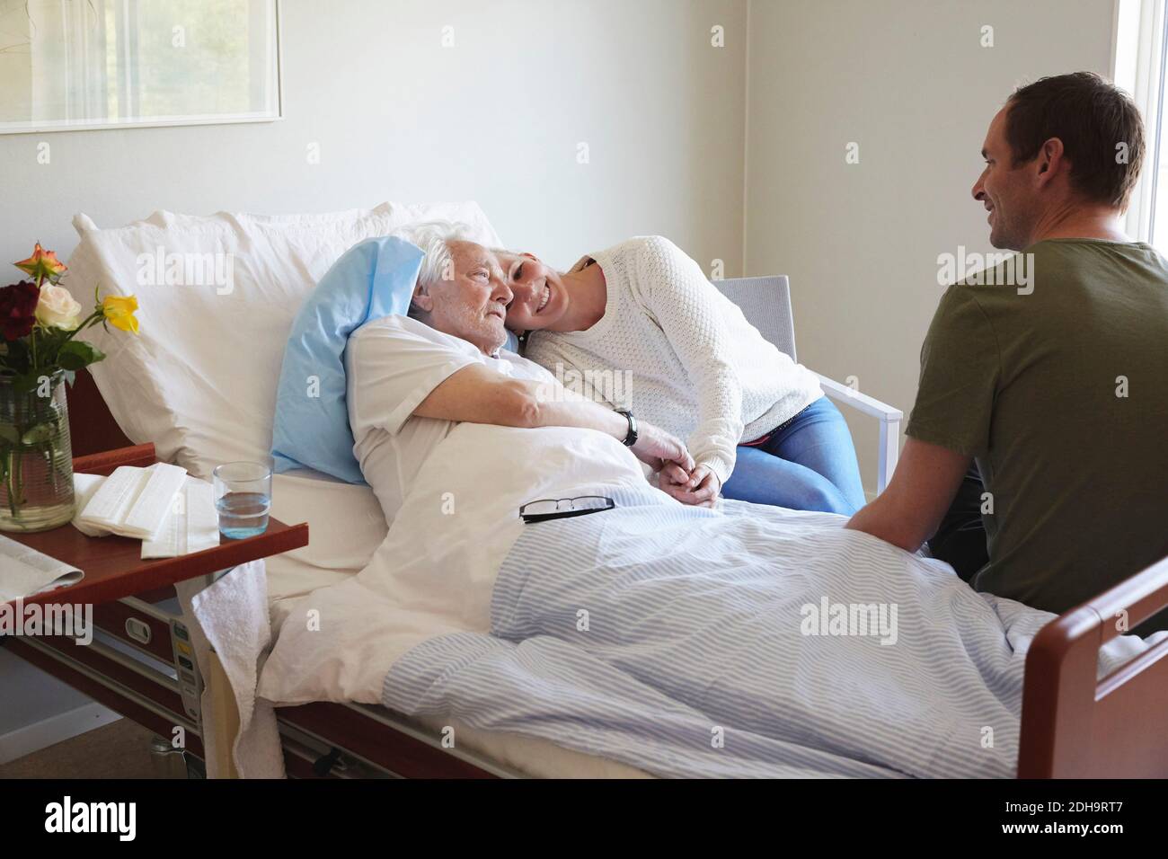 Couple visiting senior man in hospital Stock Photo - Alamy