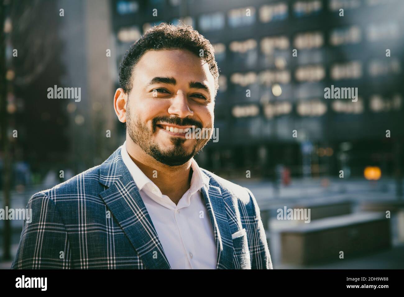 Portrait of smiling businessman standing outside office building Stock ...