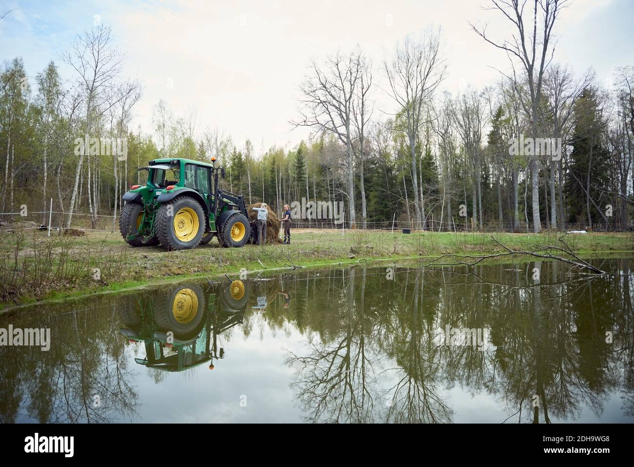 Farmers with tractor at lakeshore Stock Photo - Alamy