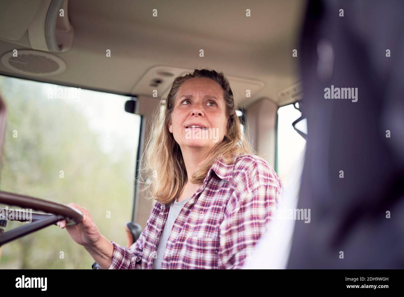 Mother looking at son while sitting in tractor Stock Photo - Alamy