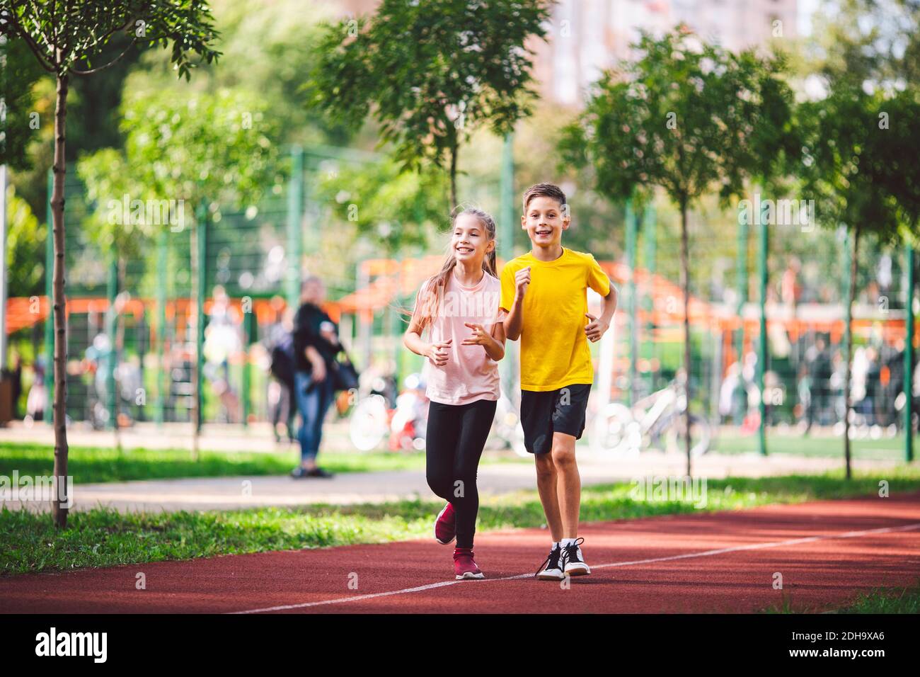 Couple of kids boy and girl doing cardio workout, jogging in park on ...